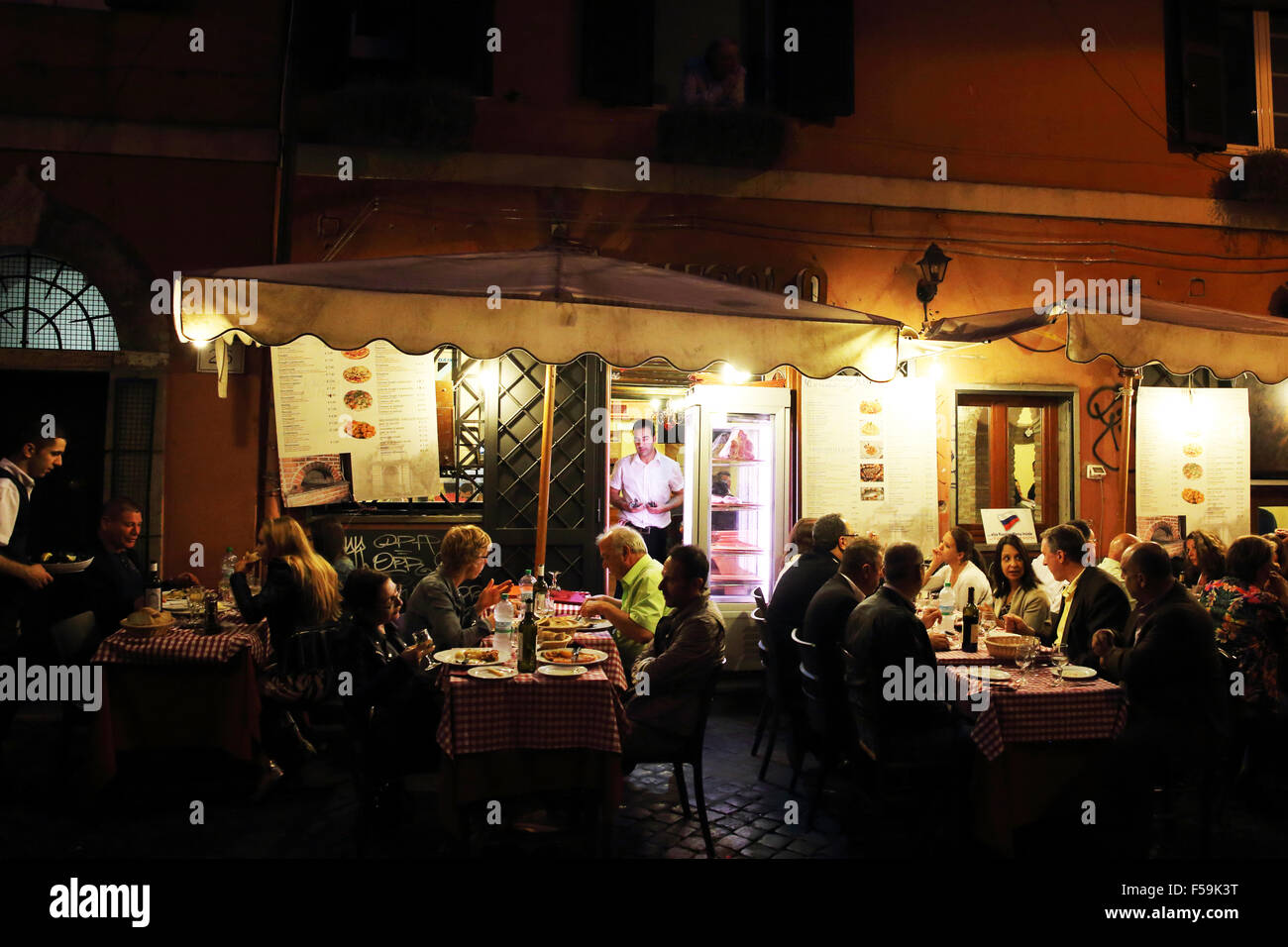 Diners enjoying eating outdoors at a small restaurant during a summer ...