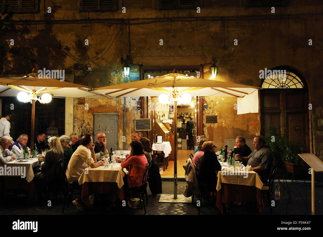 Diners enjoying eating outdoors at a small restaurant during summer in ...