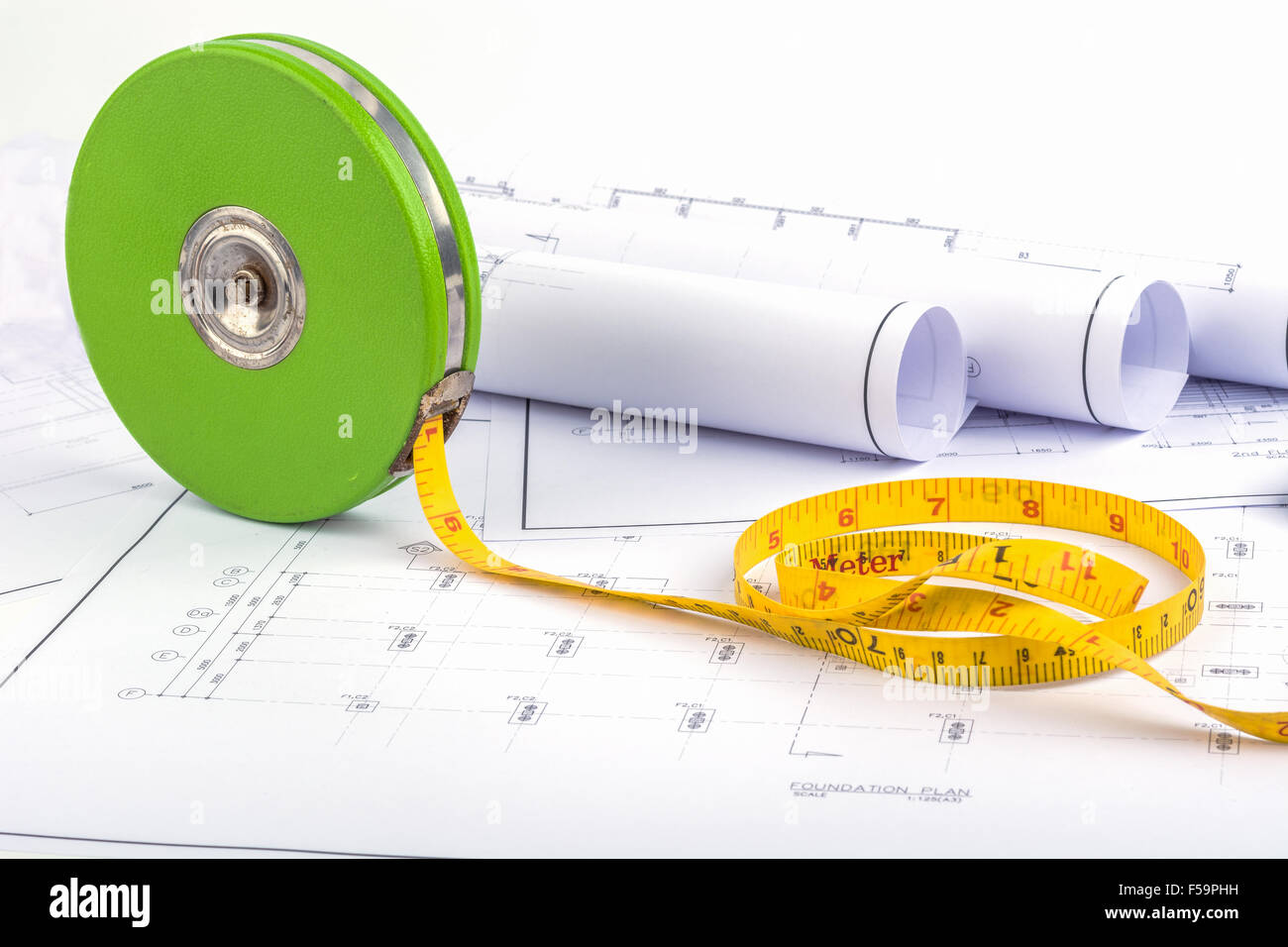 Tape measure placed on the desk, filled with building plans. In order ...