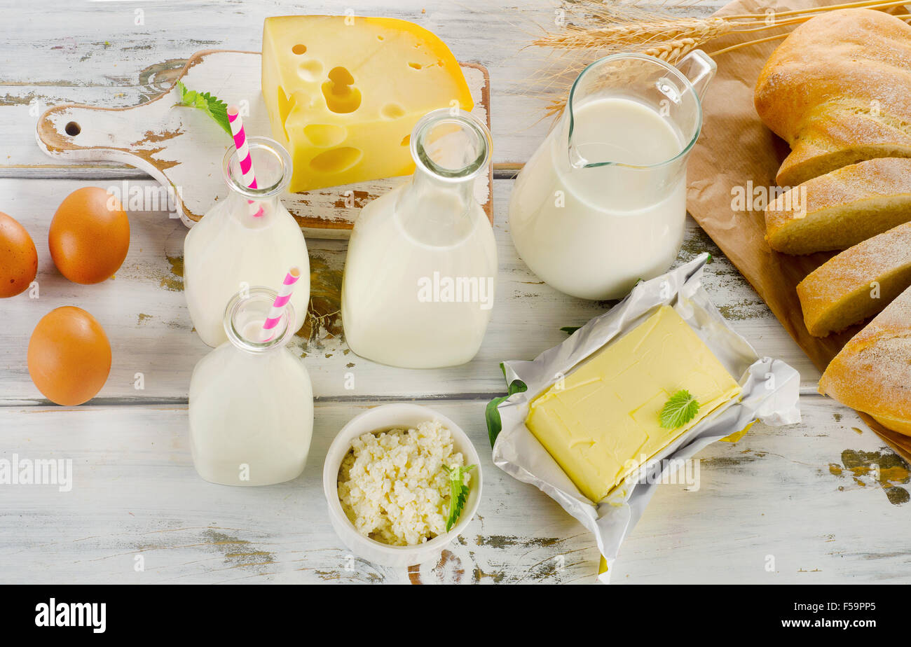 Dairy products, bread and eggs on a white wooden table Stock Photo - Alamy