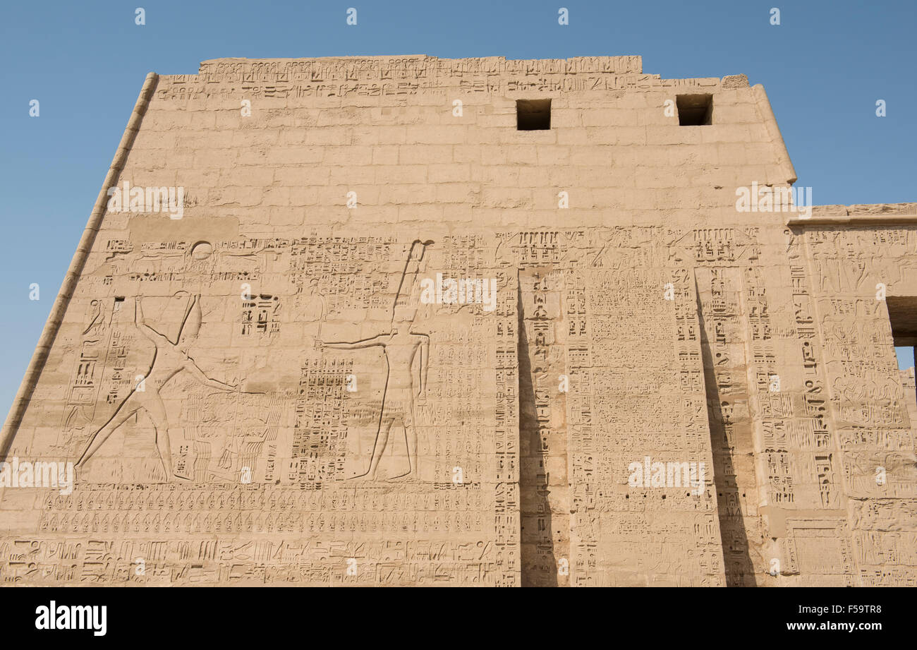 Egyptian hieroglyphic carvings on large entrance pylon wall at the ...