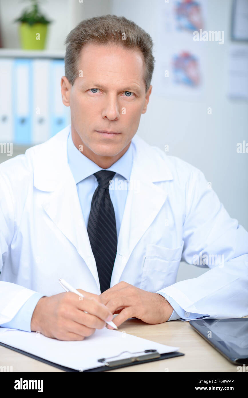 Professional doctor sitting table hi-res stock photography and images ...
