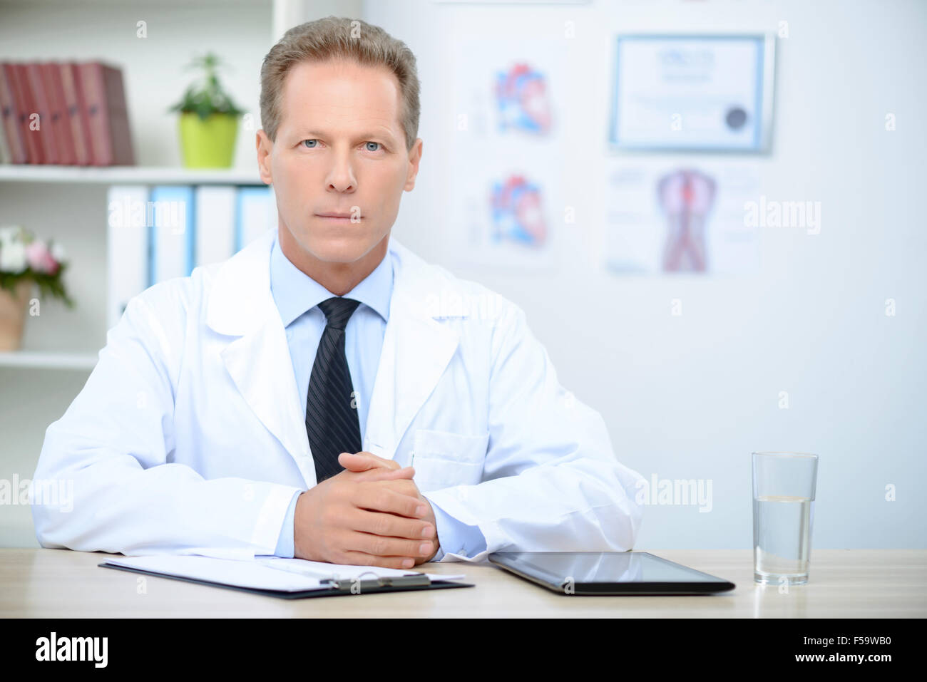 Professional doctor sitting at the table Stock Photo - Alamy