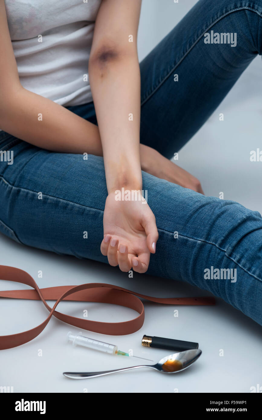 Drug addict sitting on the floor Stock Photo - Alamy