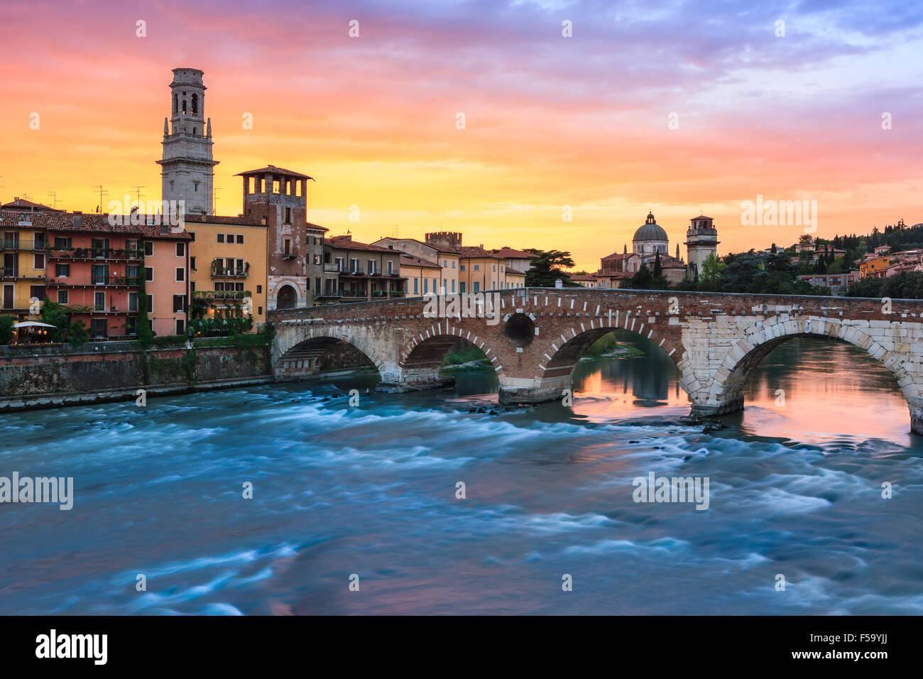 Ponte Pietra bridge at dusk over the Adige river in Verona, Italy Stock ...