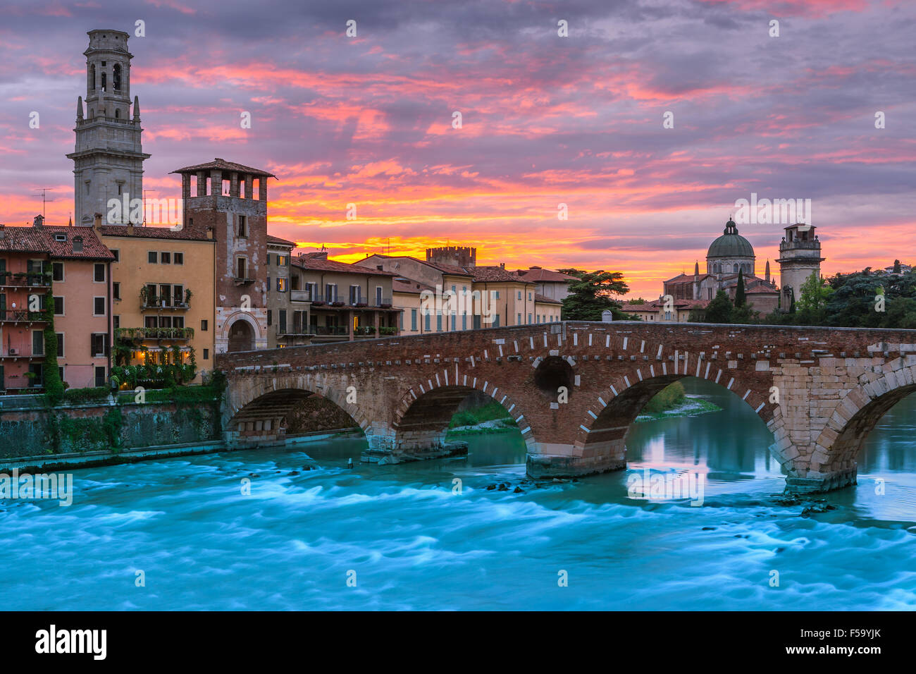 Ponte Pietra bridge at dusk over the Adige river in Verona, Italy Stock ...