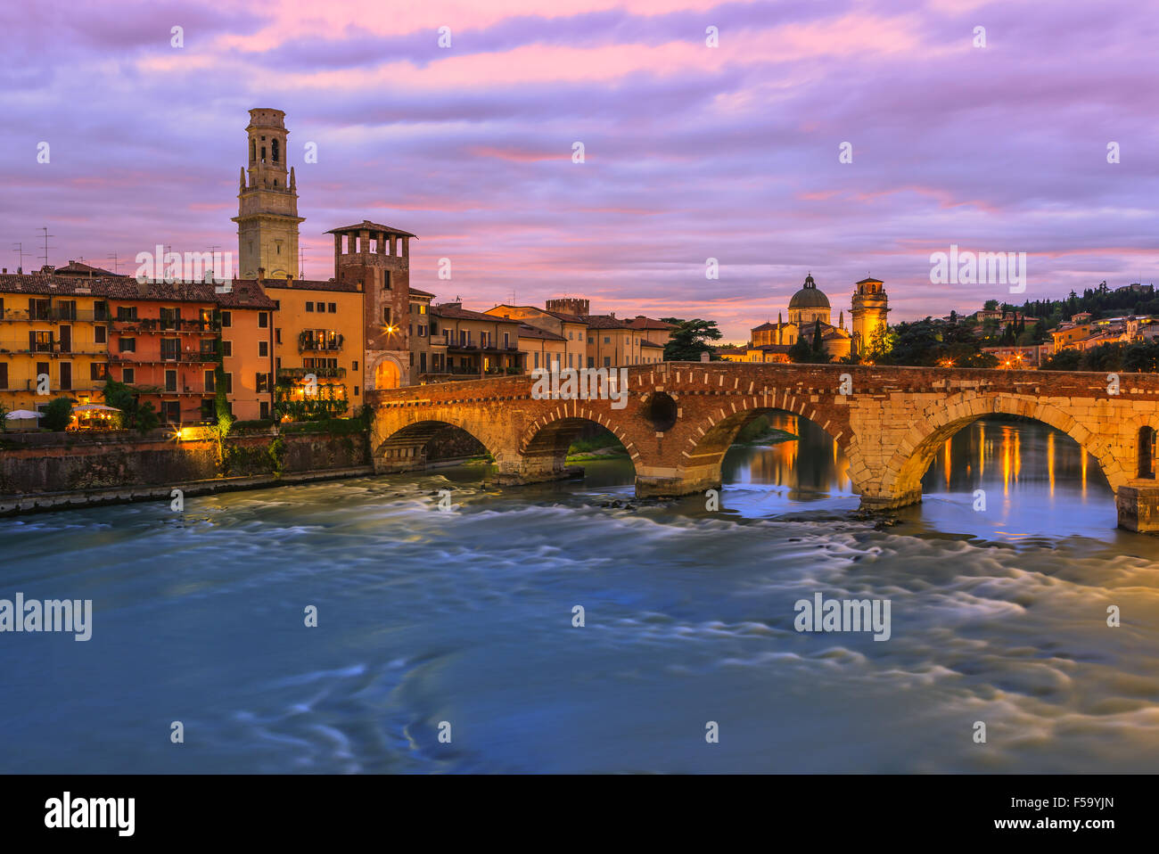 Ponte Pietra bridge at dusk over the Adige river in Verona, Italy Stock ...