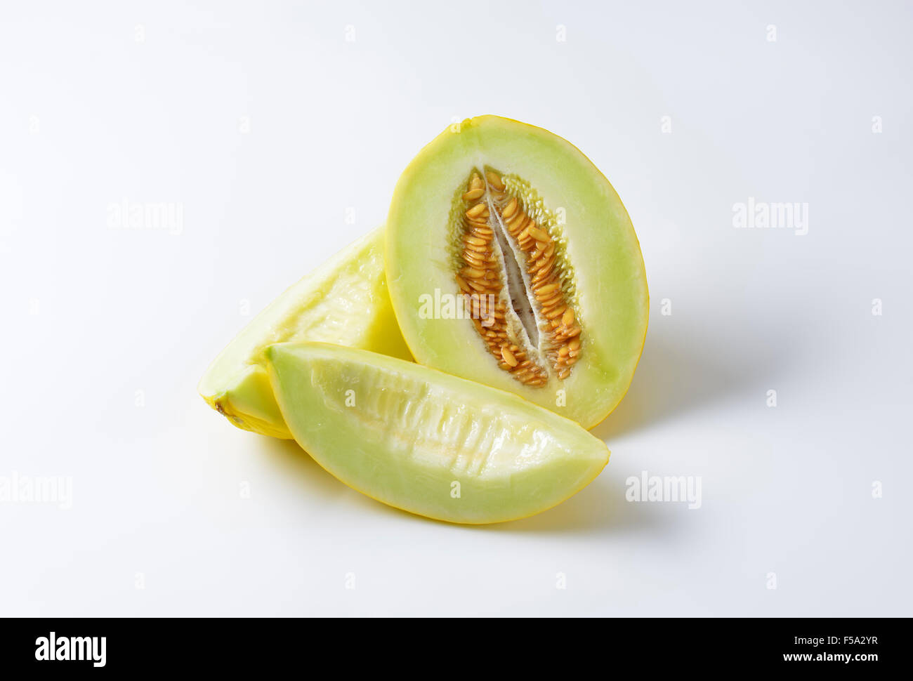 Yellow melon half and slices on white background Stock Photo - Alamy