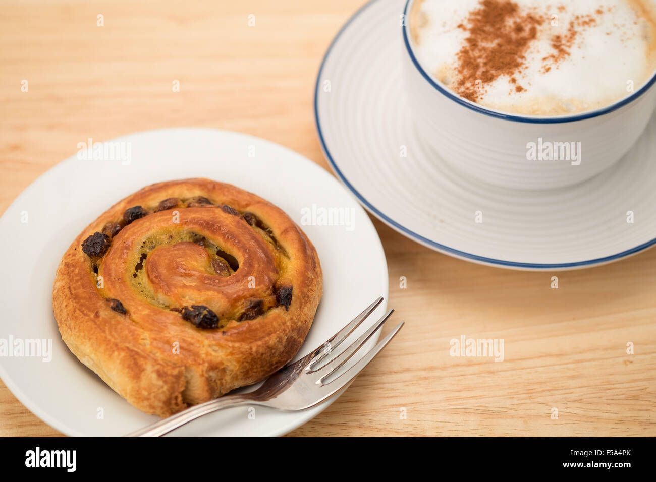A fresh Pain au raisin and a cappuccino breakfast Stock Photo - Alamy