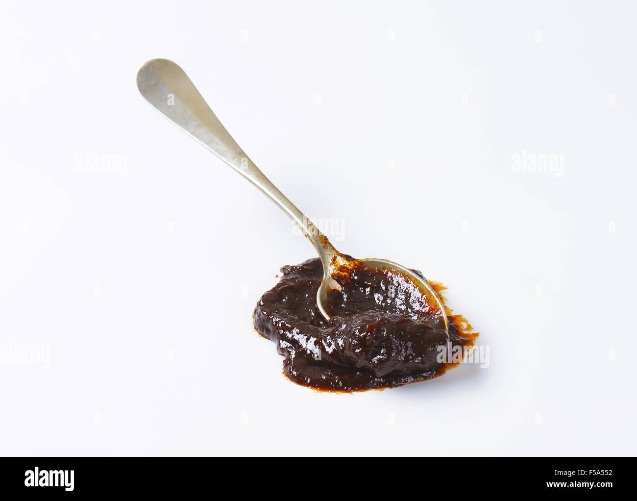Spoon of plum jam on white background Stock Photo - Alamy