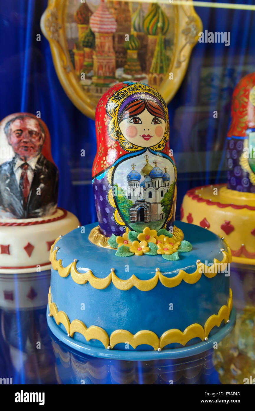 A marzipan model of a hand painted figurine on top of a small bright ...