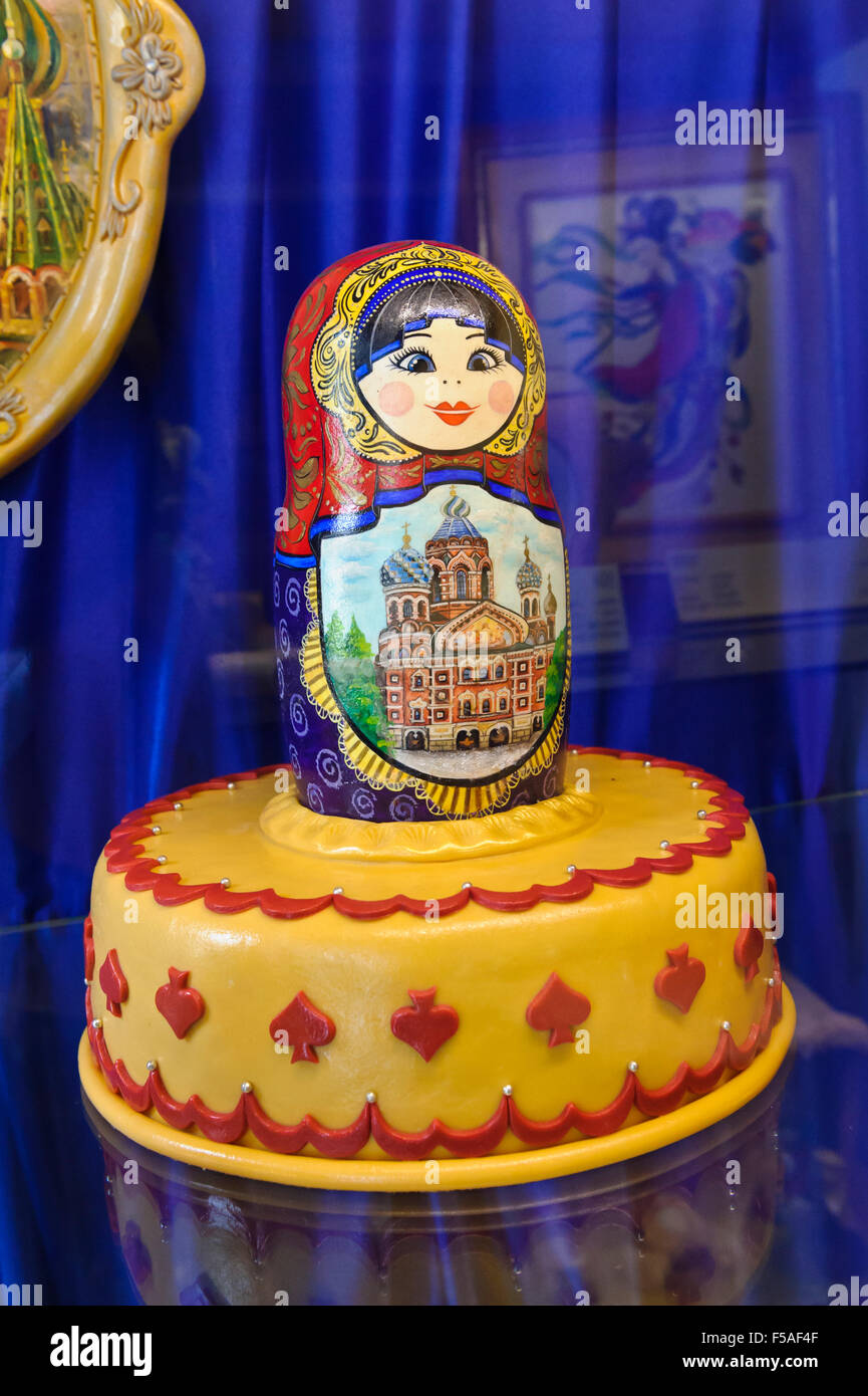 A marzipan model of a hand painted figurine on top of a small bright ...