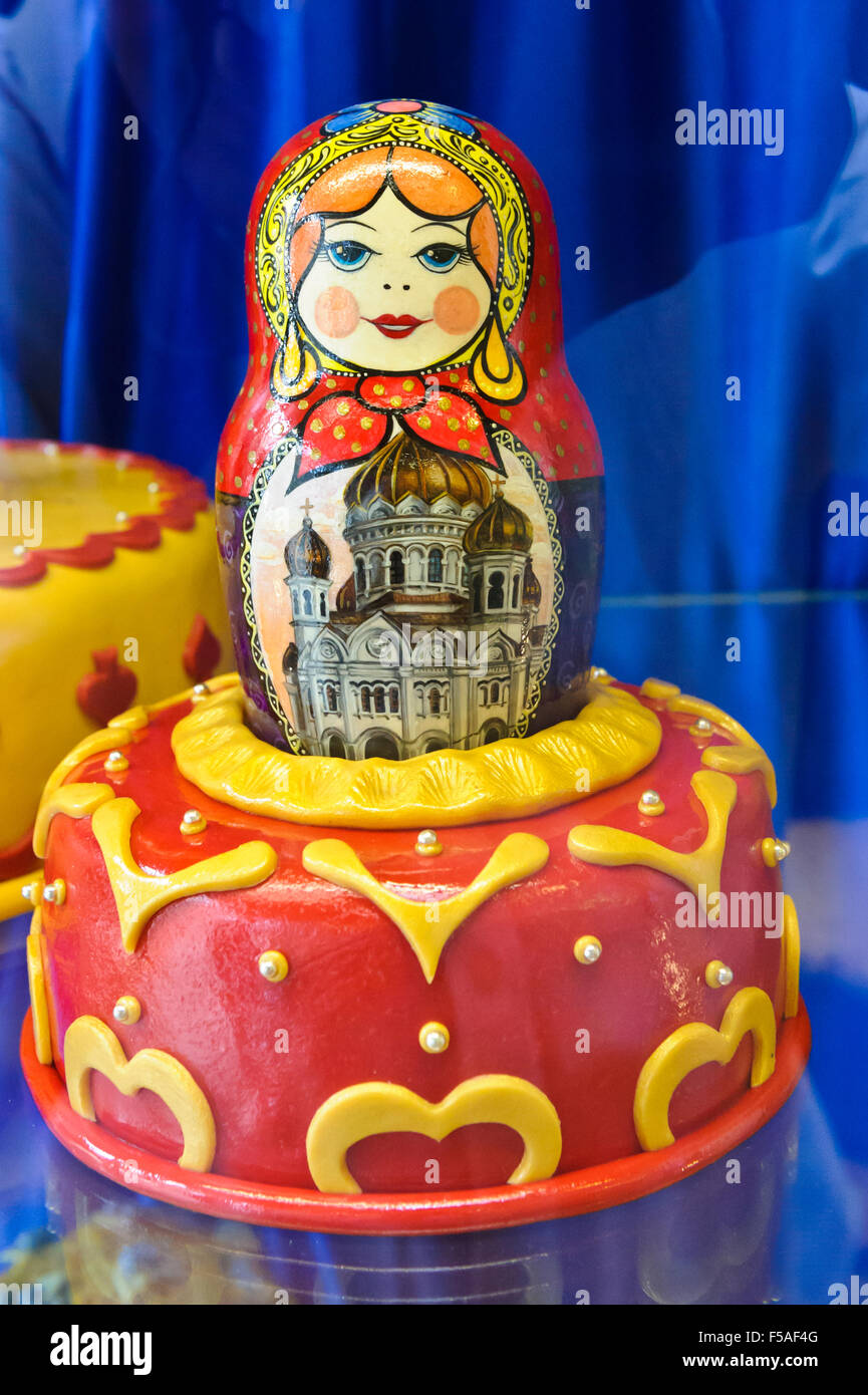 A marzipan model of a hand painted figurine on top of a small bright ...