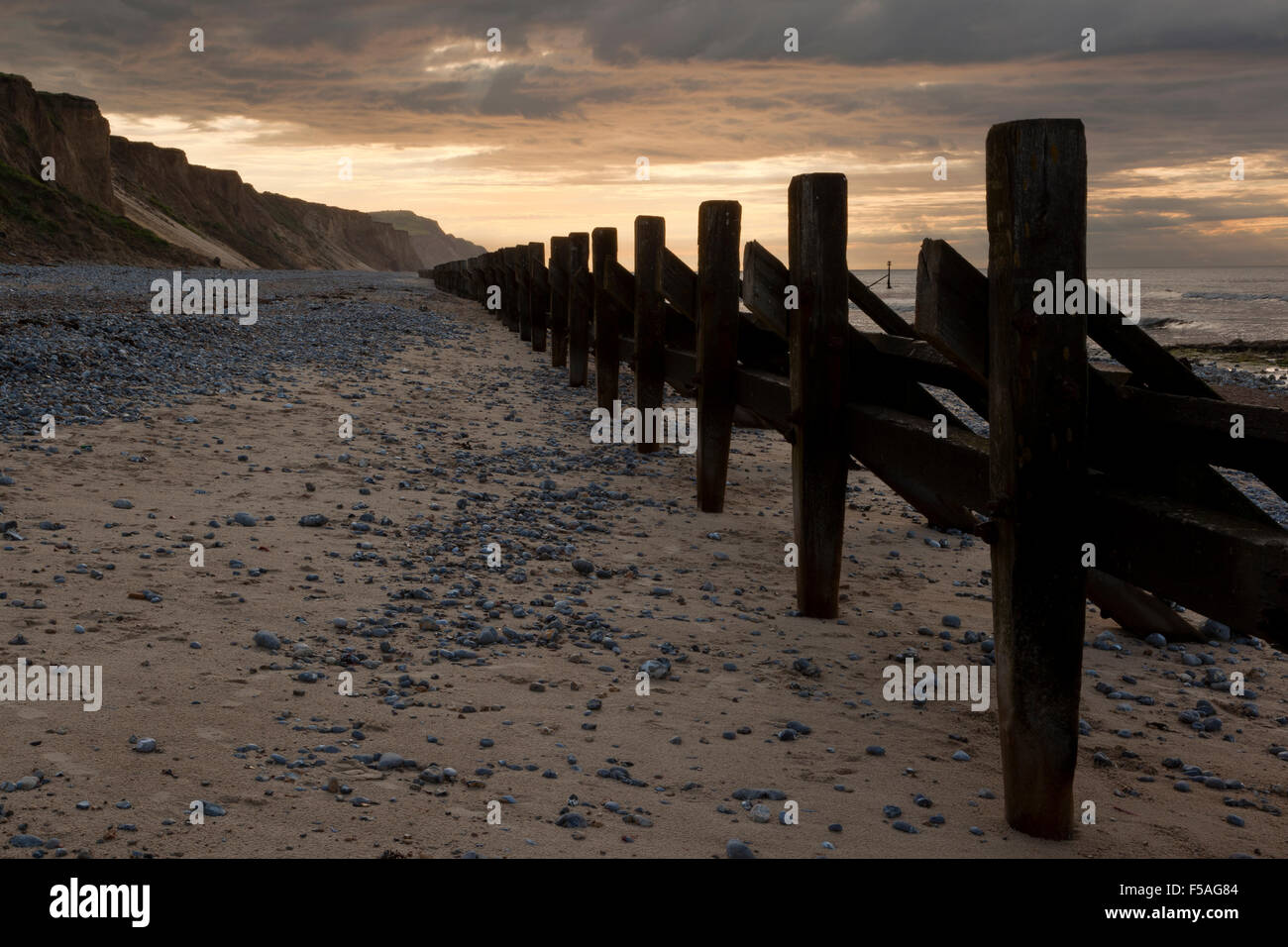 Wooden coastal sea defenses and receding cliff line at West Runton ...