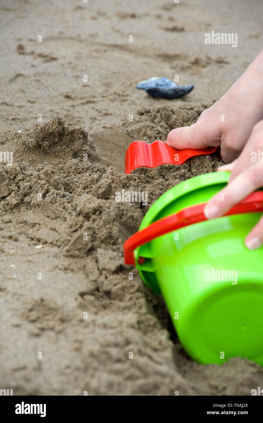 Boy playing with bucket and spade in the sand hi-res stock photography ...