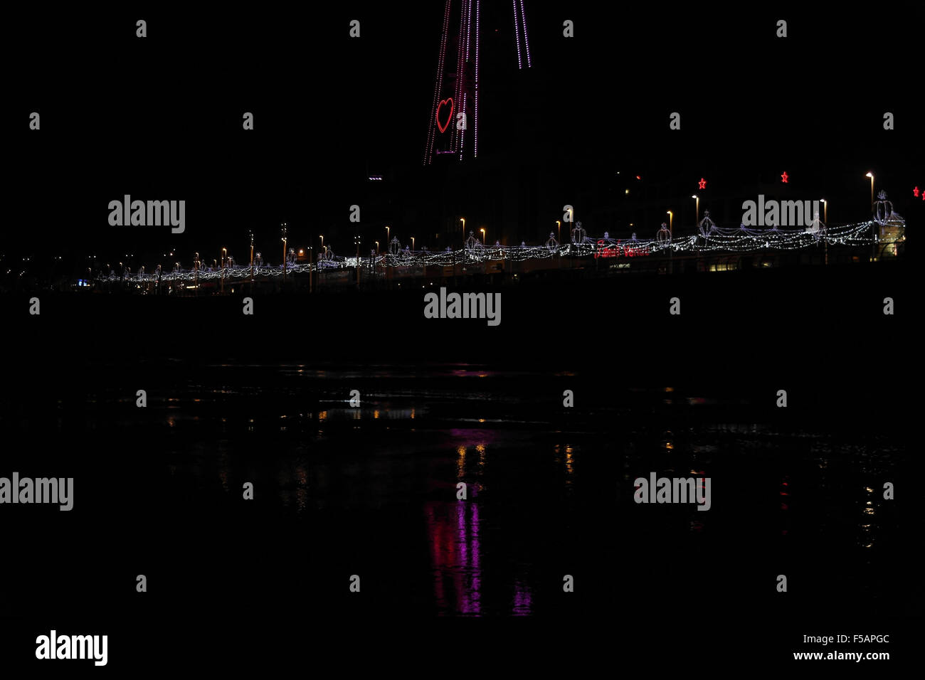 Night oblique beach view, with reflections, to blue 'Bling' and red ...
