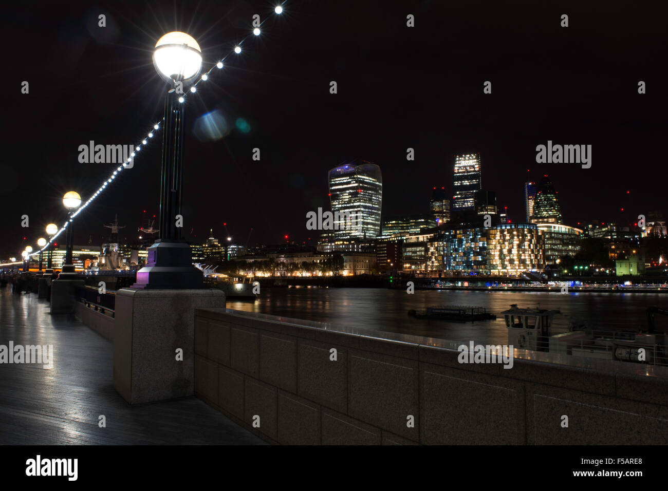 The river Thames passing quietly in front of a bright London skyline at ...