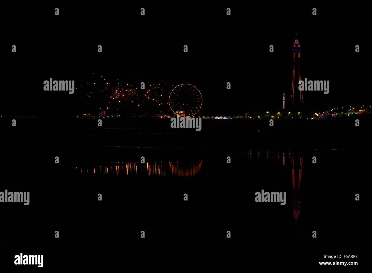 Night beach reflections view north to red Blackpool Tower and fireworks ...