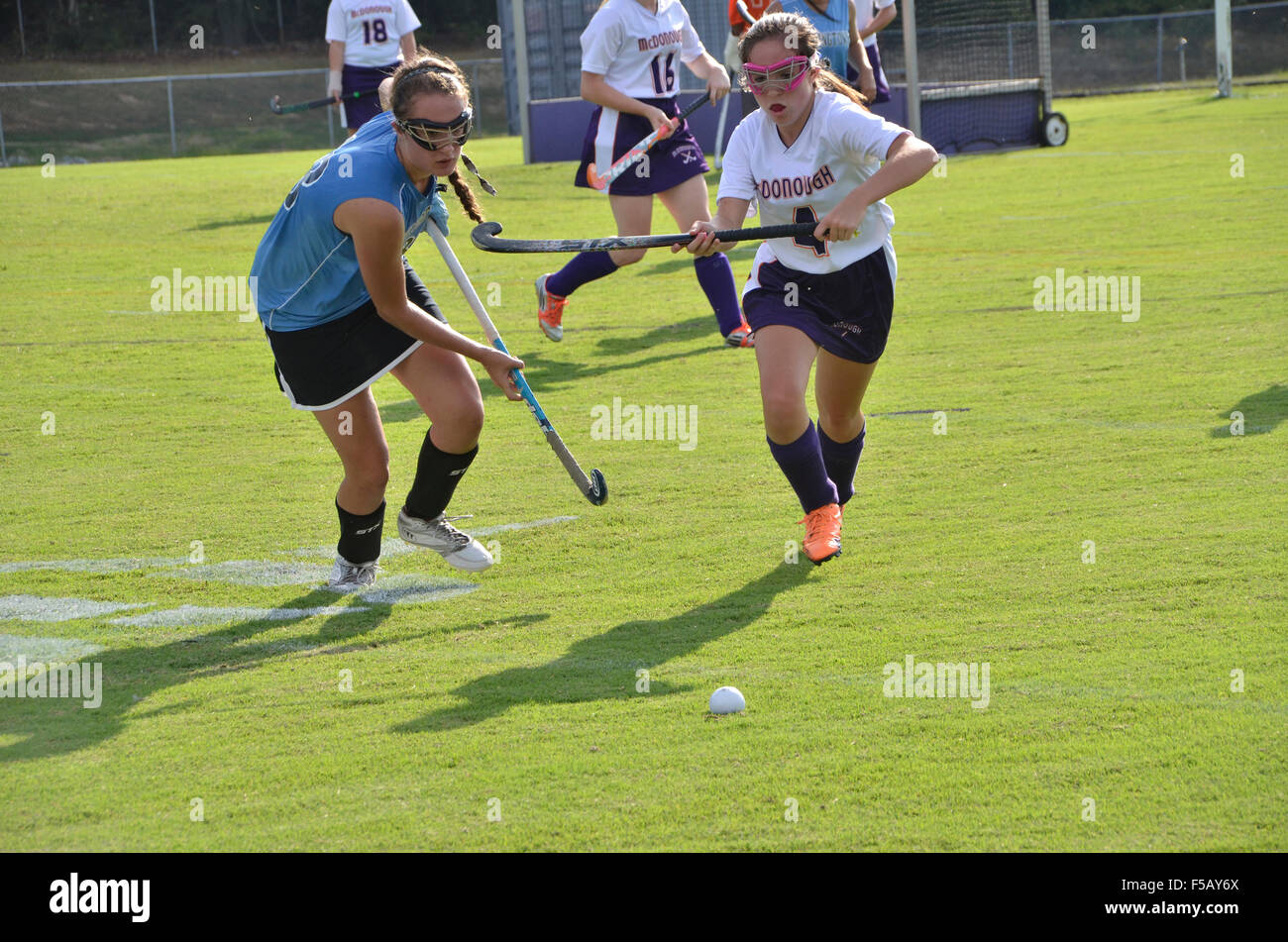 Girls playing field hockey in a high school game Stock Photo - Alamy
