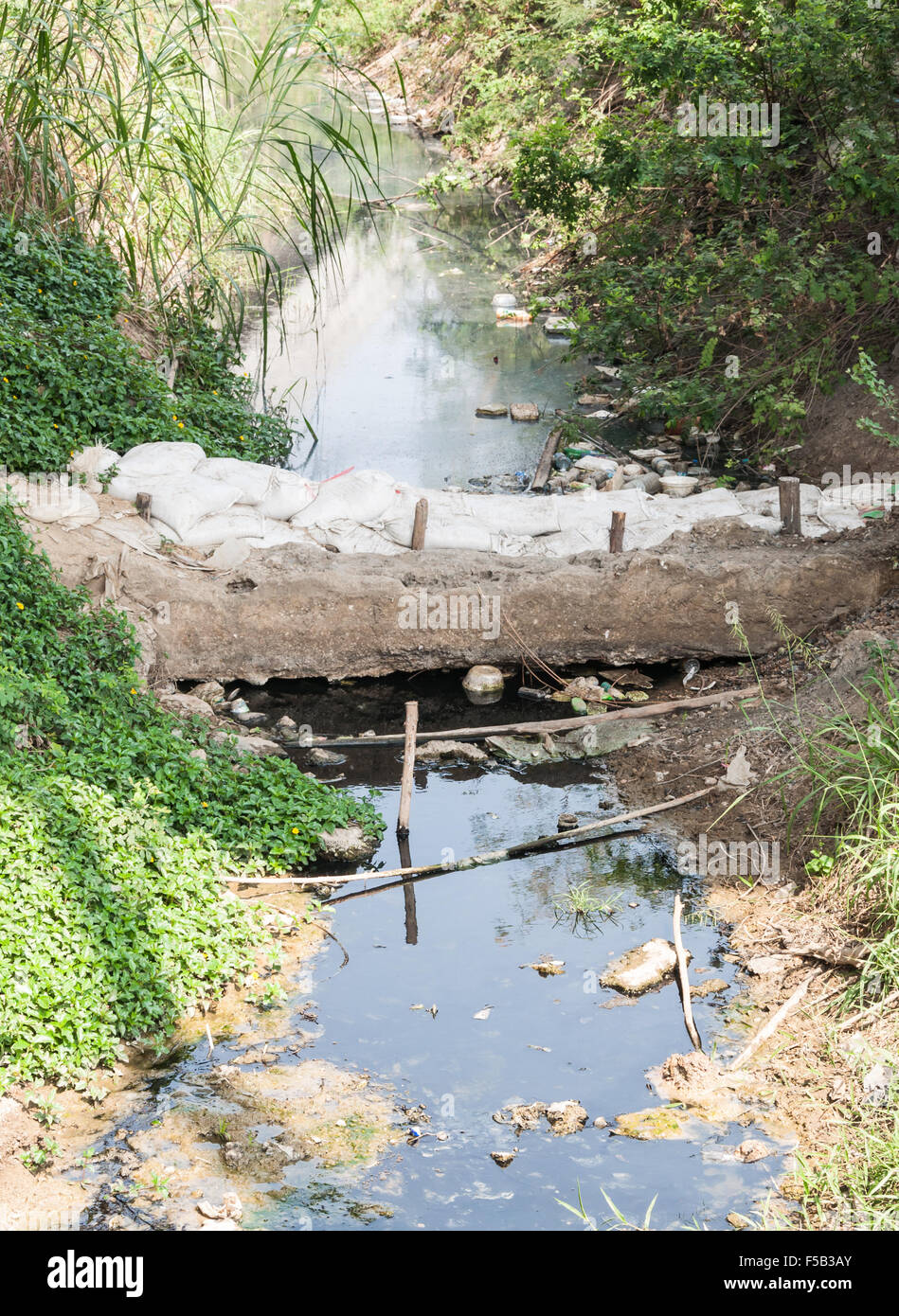 Waste water canal with small sandbag dam from the industry estate Stock ...
