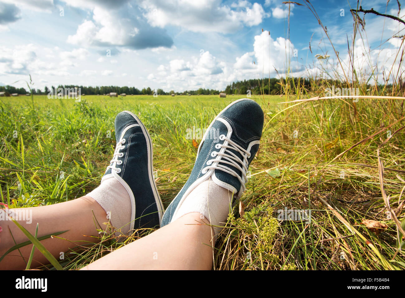 Feet at field with beautiful clouds Stock Photo - Alamy