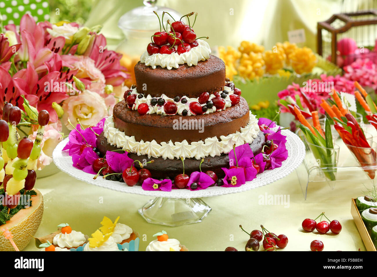 Layer cake decorated with whipped cream and cherries. This image has a ...