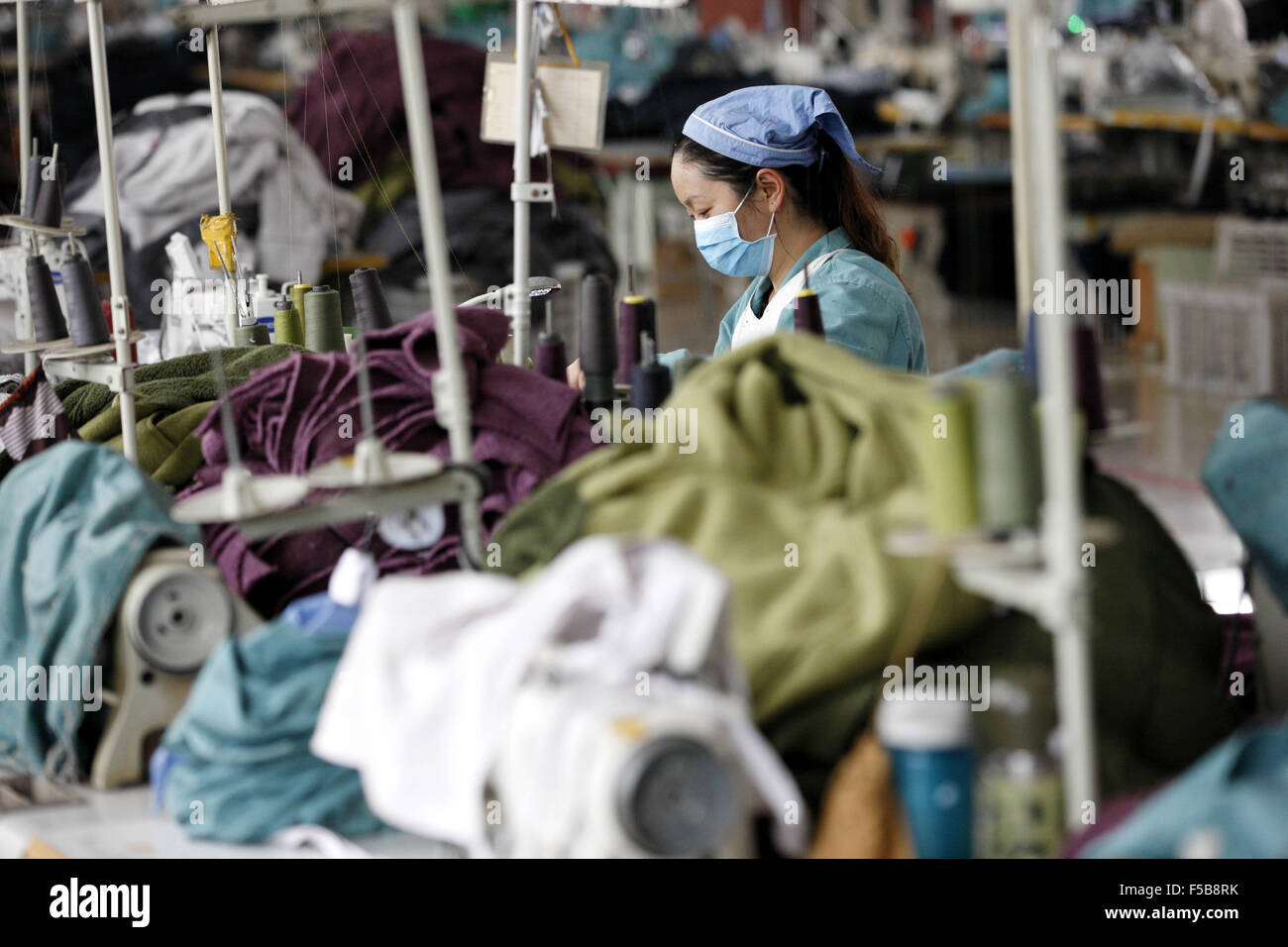 A female labour works in a clothes factory in Huaibei, Anhui province ...