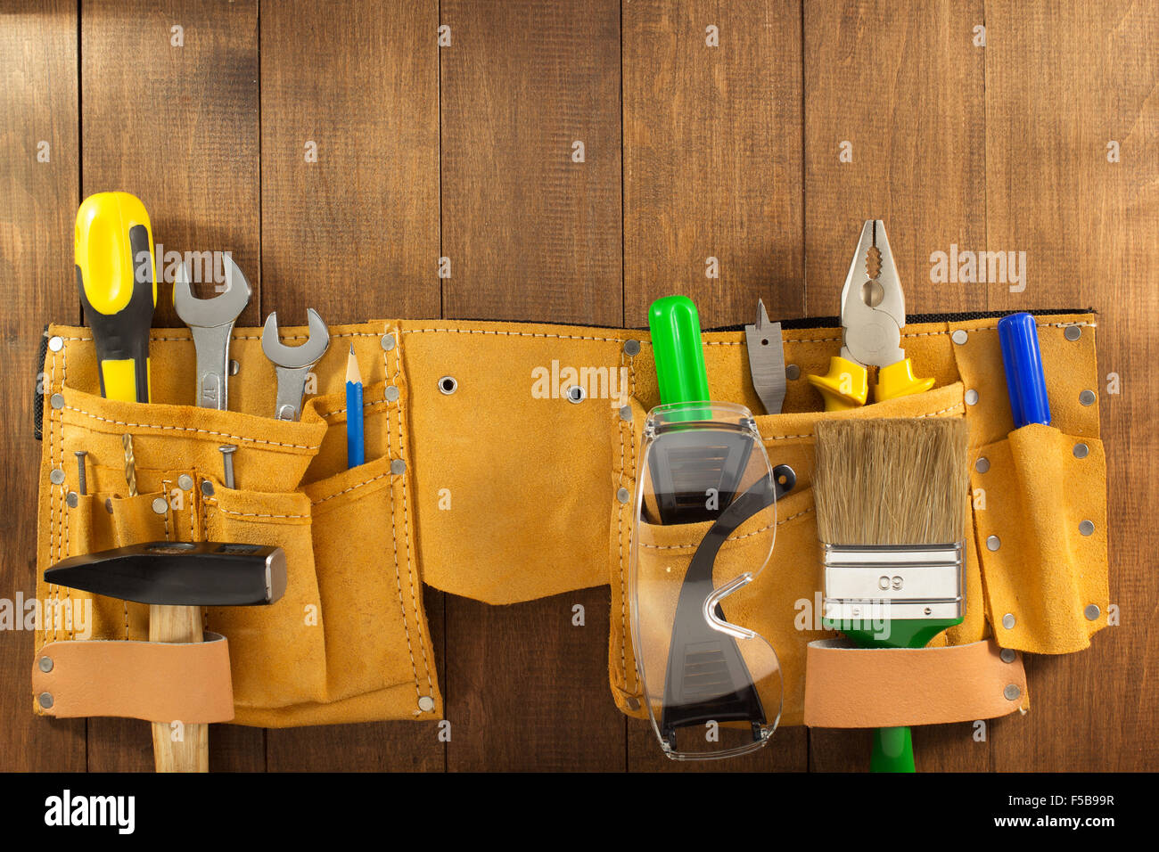 tools and instruments in belt on wooden background Stock Photo - Alamy