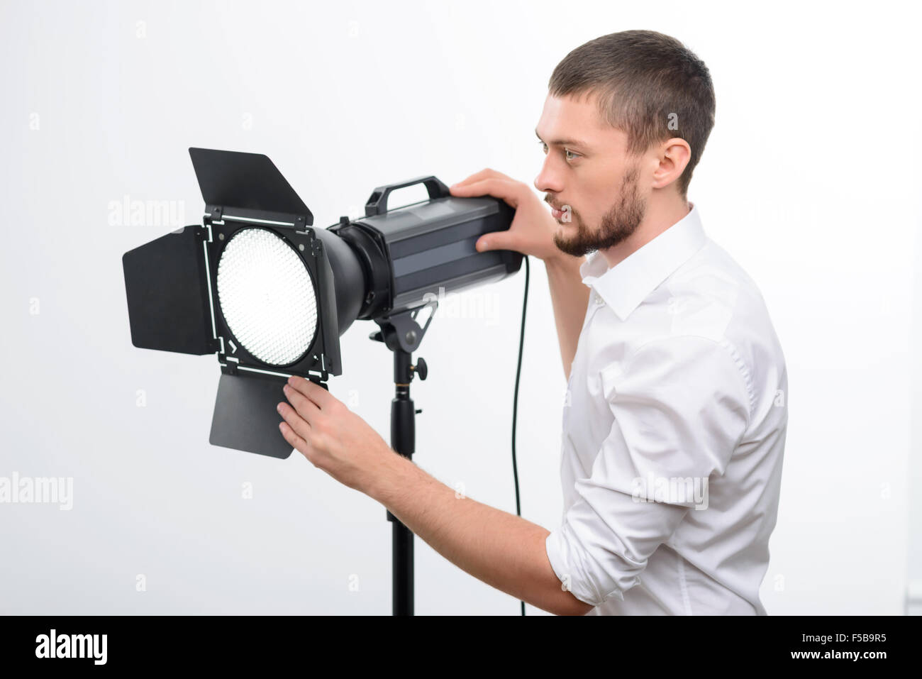 Young male professional photographer is busy fixing the spotlight Stock ...