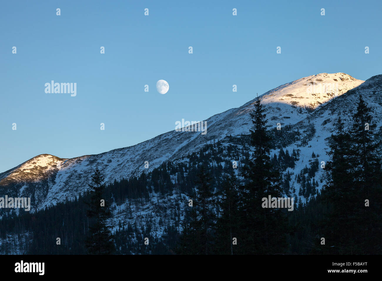Moonrise in winter mountains Stock Photo - Alamy