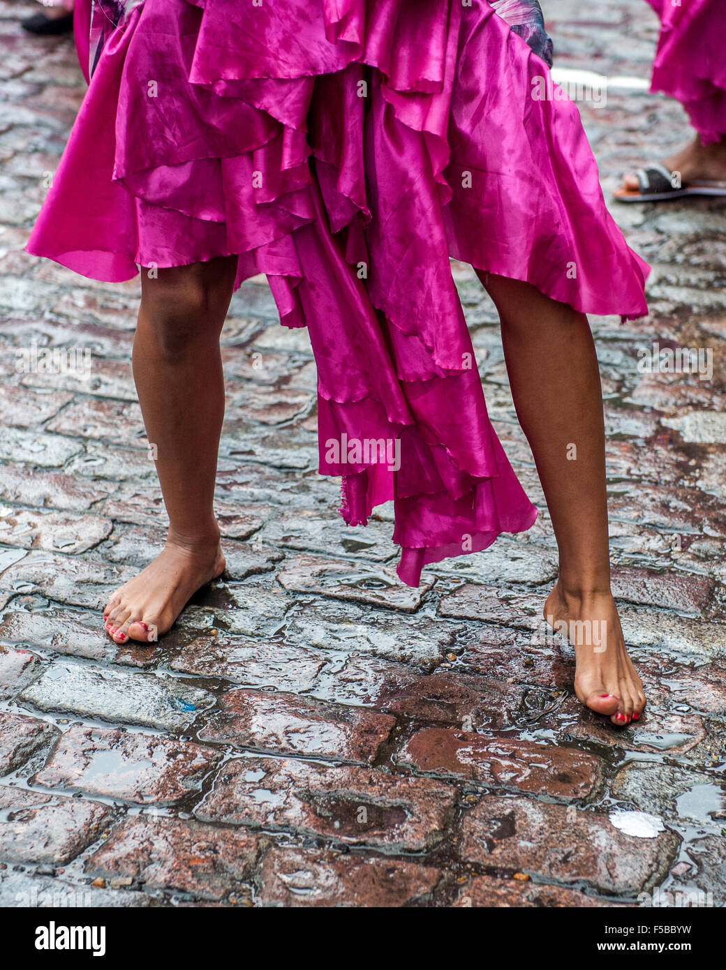 Performers in colourful costumes dance through the rain during the ...