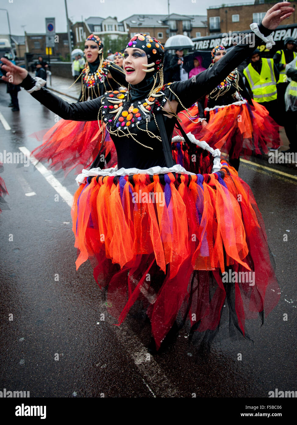 Performers in colourful costumes dance through the rain during the ...