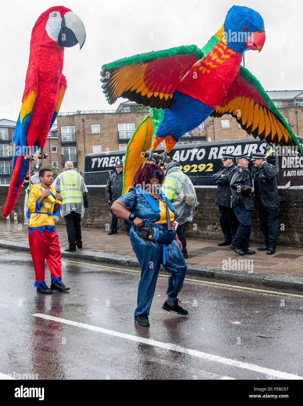 Performers in colourful costumes dance through the rain during the ...