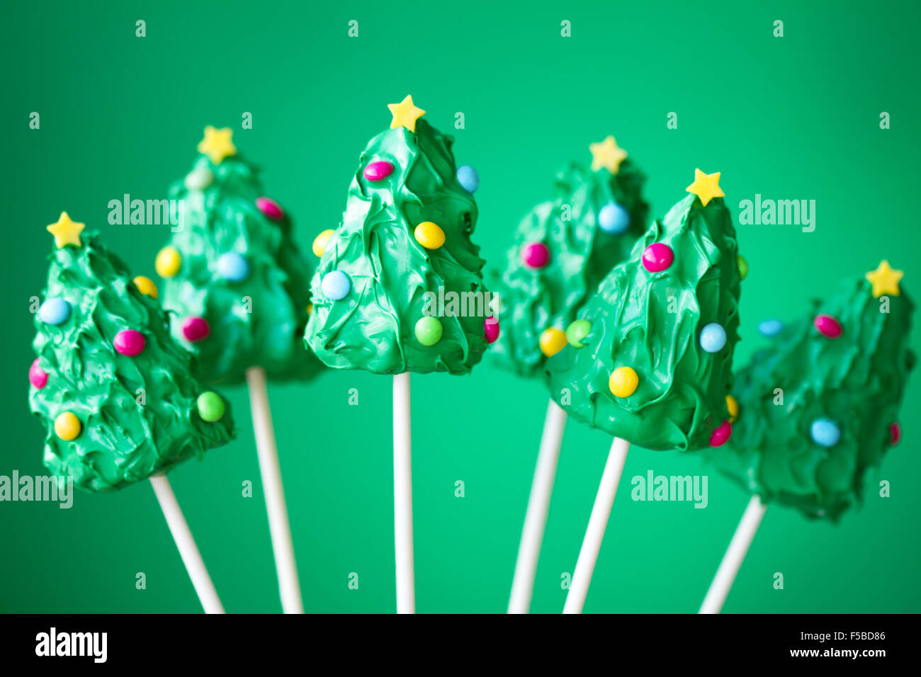 Christmas tree cake pops against a green background Stock Photo - Alamy
