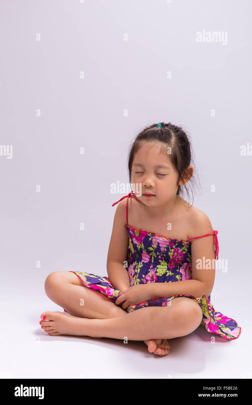 Little girl does mediation alone on with white background Stock Photo ...