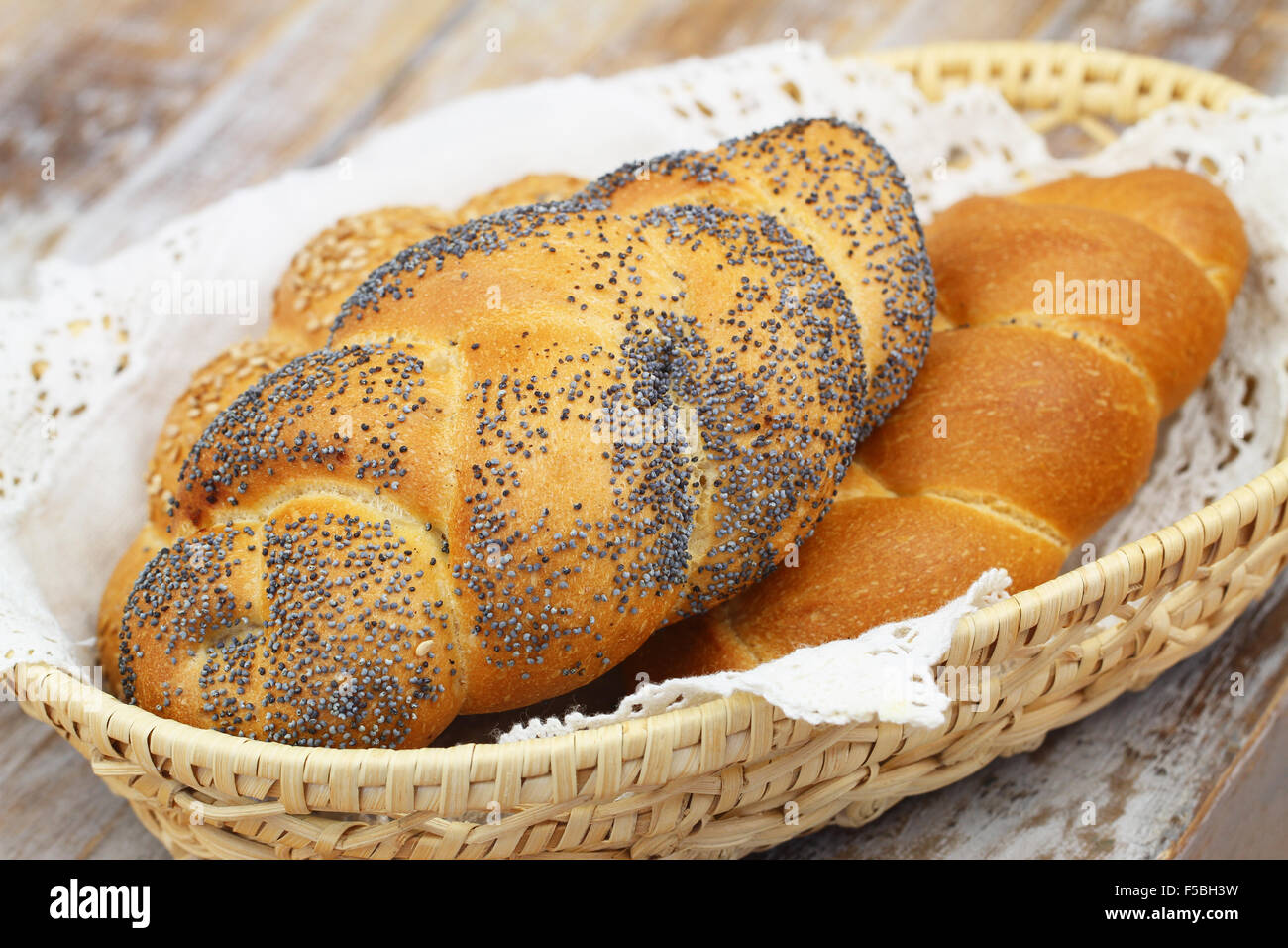 Challah bread with poppy seeds, sesame seeds and plain in bread basket ...