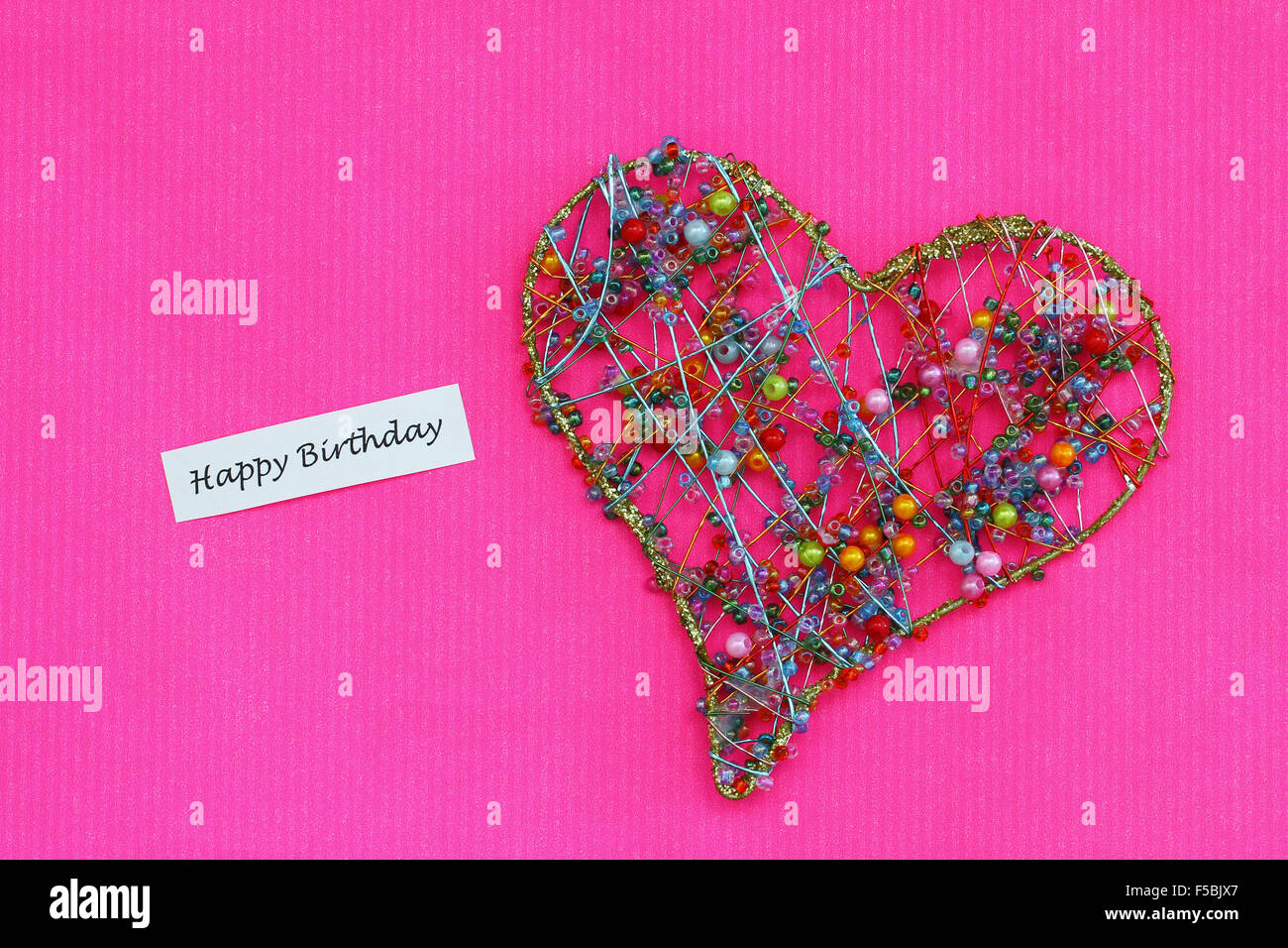 Happy Birthday card with heart made of colorful beads on pink ...