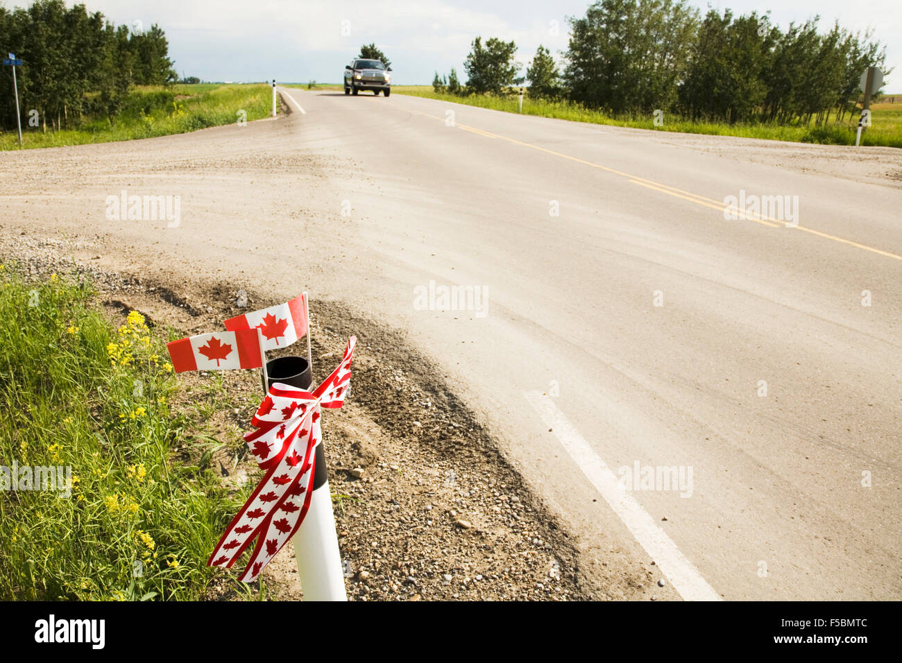 Canada flag on Alberta rural road Stock Photo - Alamy