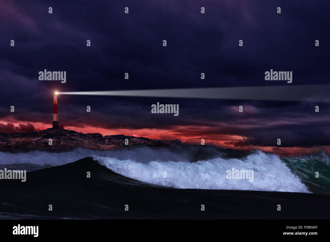 Lighthouse on the rocks in storm ocean Stock Photo - Alamy