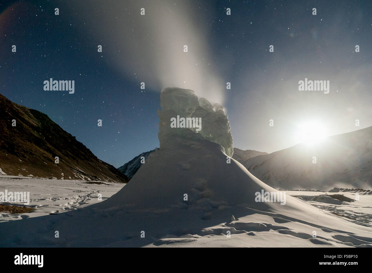 Steam pouring out of a beautiful frozen volcano-like hot spring geyser ...