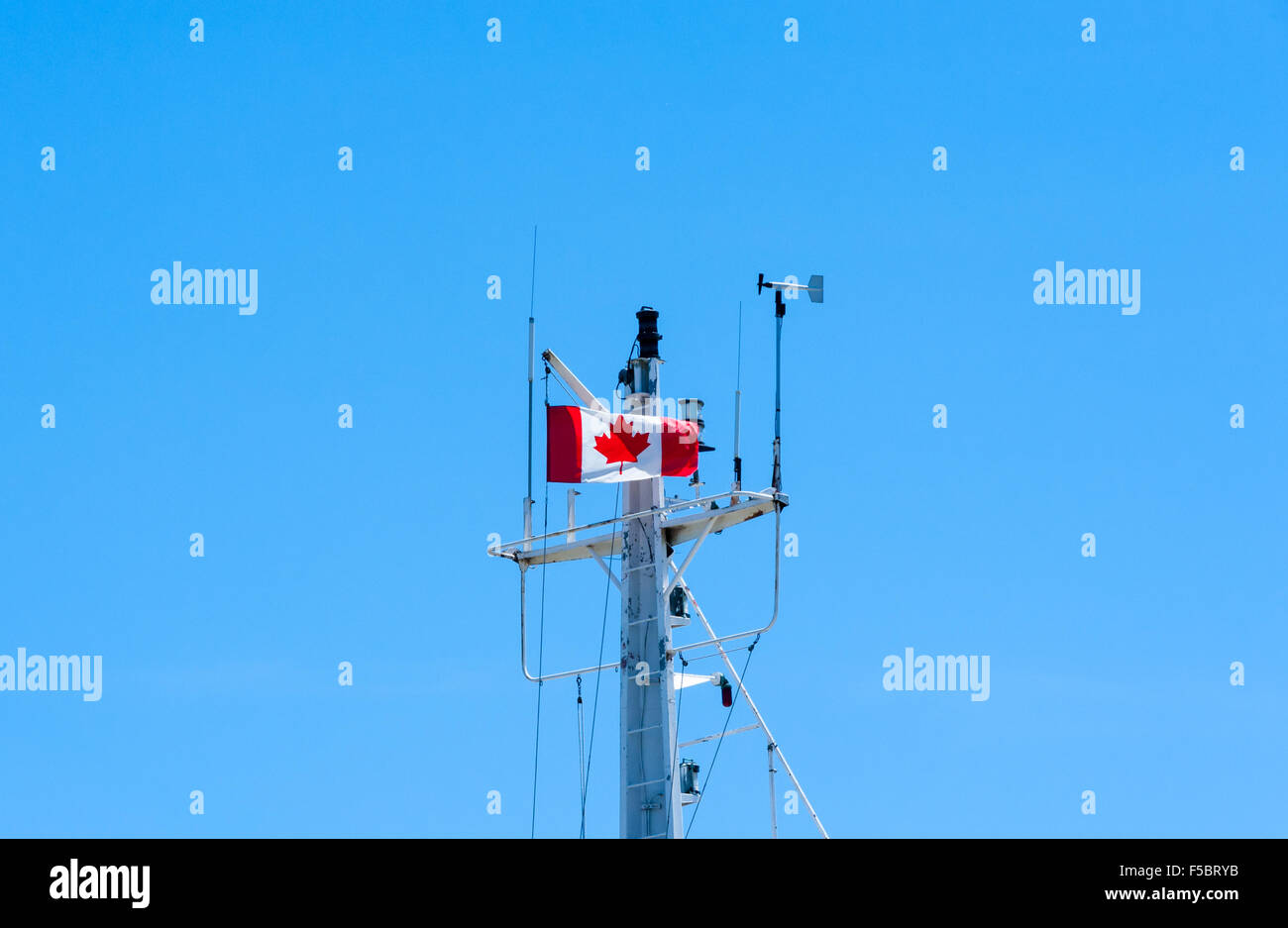 Top of modern metal ship mast against empty blue sky copy space, with ...