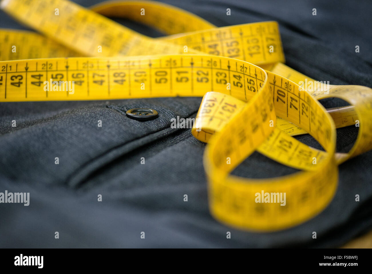 Measuring tape on pants in a tailor workshop, closeup Stock Photo - Alamy