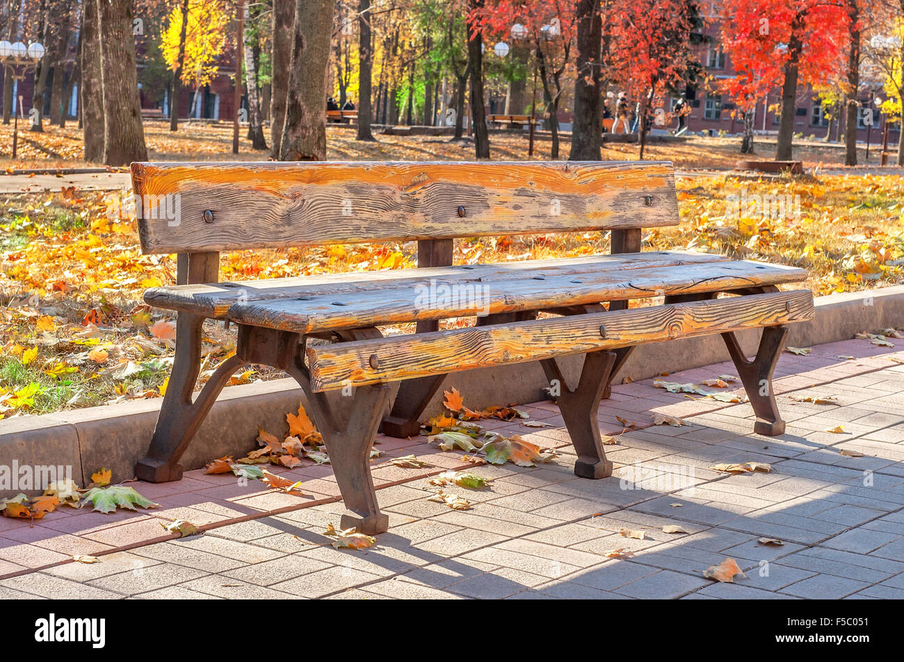 Lonely old bench in autumn city park on a sunny day Stock Photo - Alamy