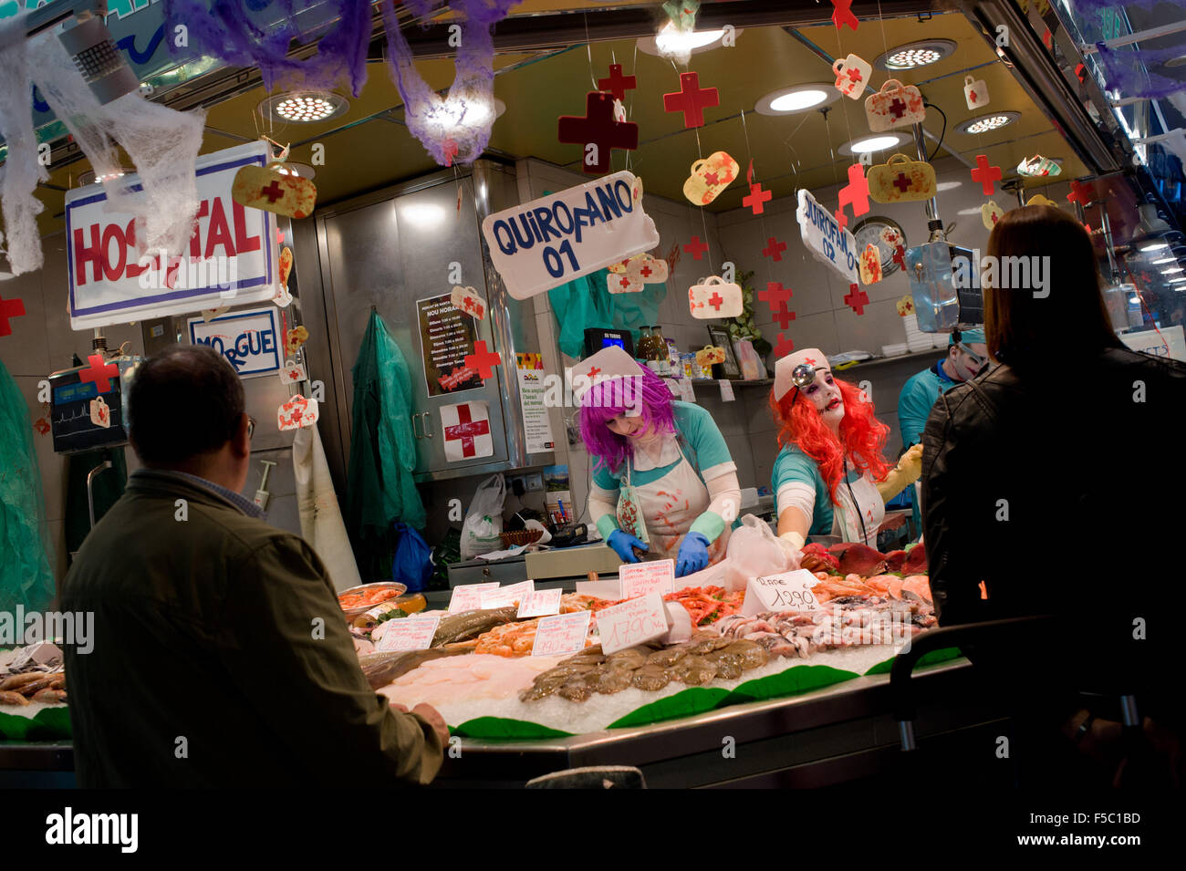 Vendors of a fish stall dressed in their Halloween costumes attend ...