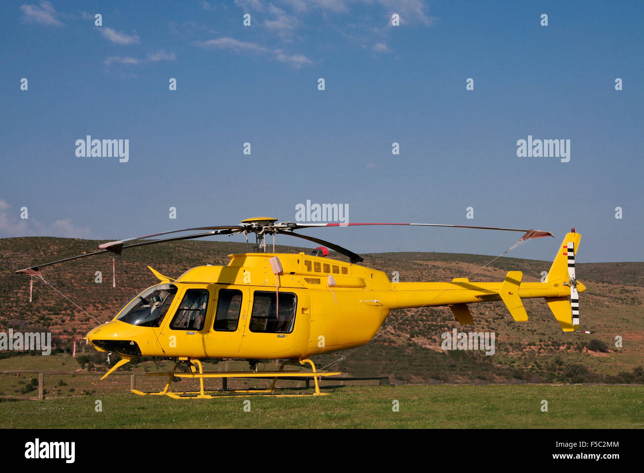 Yellow fire brigade helicopter on land, Spain Stock Photo - Alamy