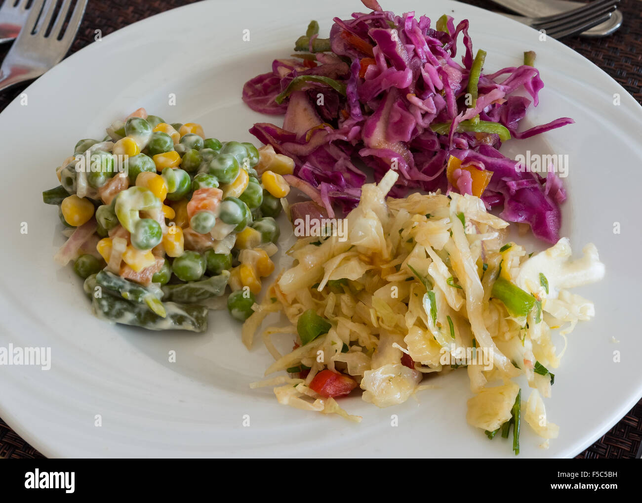 Pictured are three types of salads served on white dish at the ...