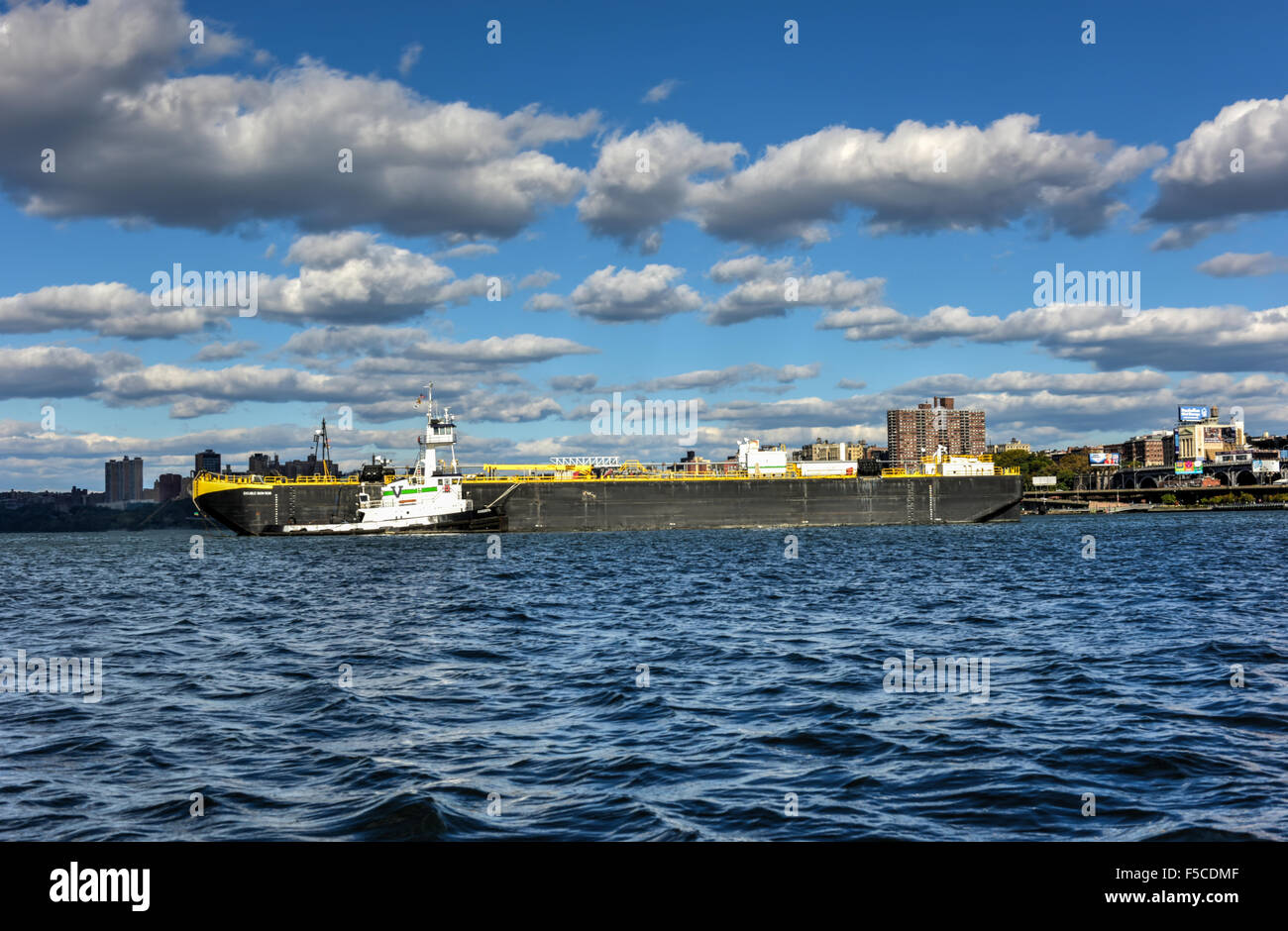 Tug boat serving a container ship in the Hudson River off of Manhattan ...