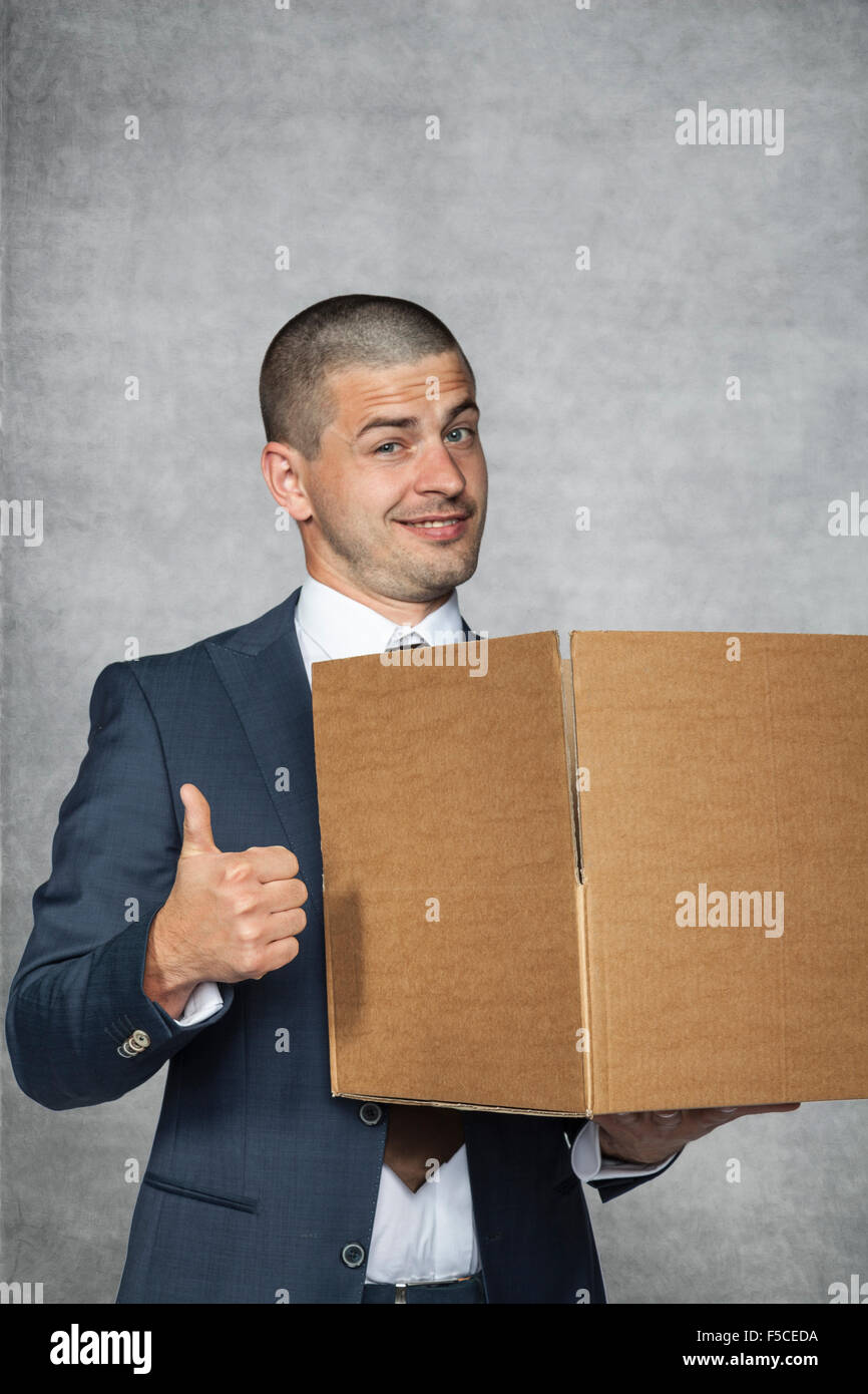 businessman holds a box of experience, thumbs up Stock Photo - Alamy