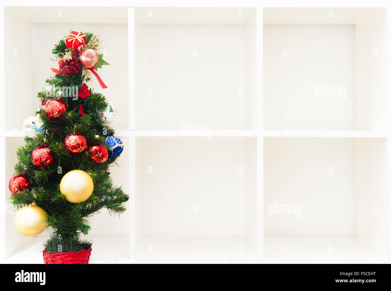 Christmas tree on empty white bookshelf with six cubic boxes and copy ...