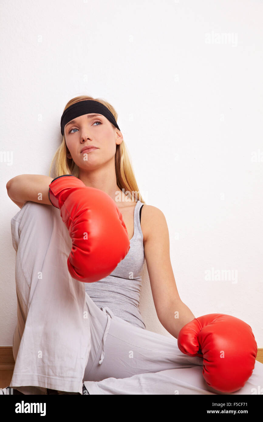 Young female boxer sitting on the floor Stock Photo - Alamy